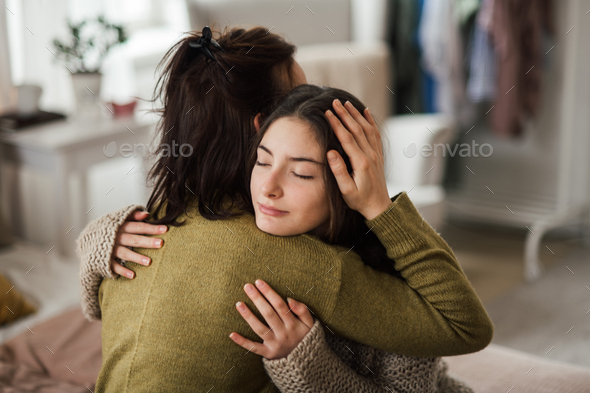 Teenage girl hugging her mother at home. Stock Photo by halfpoint ...