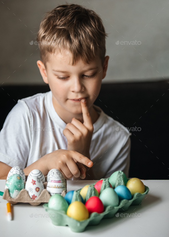 Child paints eggs with different colors. Stock Photo by suesik89 ...