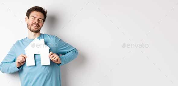 Real estate and insurance concept. Dreamy young man smiling with closed ...