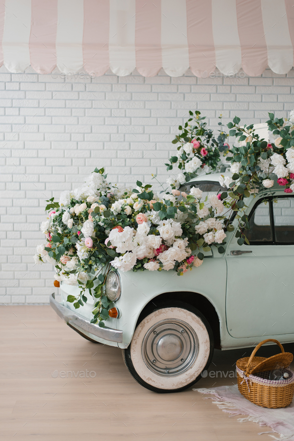 Retro mint car decorated with flowers in the photo zone in a romantic ...