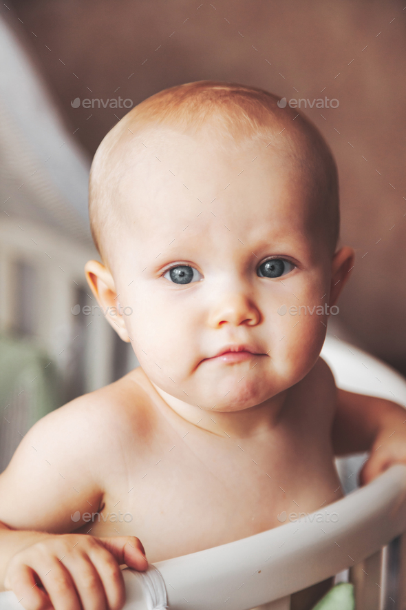 Portrait of serious adorable baby with beauty blue eyes interested from ...