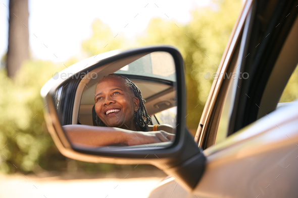 Smiling Senior Female Driver Looking Out Of Car Window Enjoying Day ...