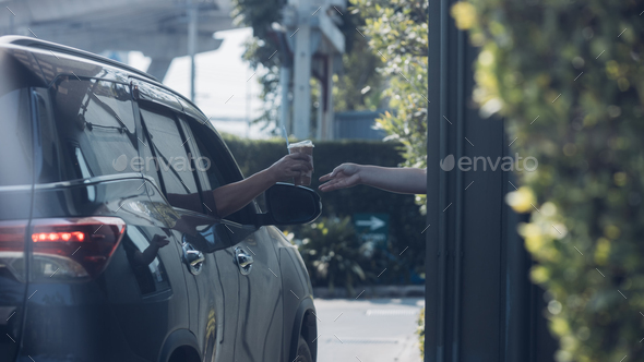 Hand Man in car receiving coffee in drive thru fast food restaurant ...