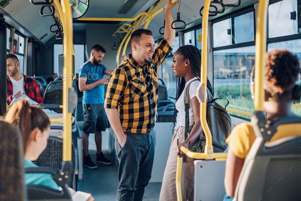 Multiracial friends talking while riding a bus in the city Stock Photo ...