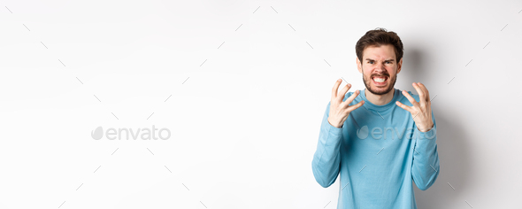 Angry caucasian man shaking hands and grimacing, looking with mad face ...