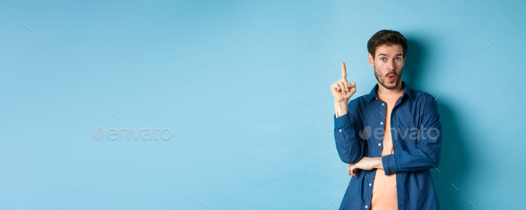 Handsome young man having an idea, pitching plan, raising finger and ...