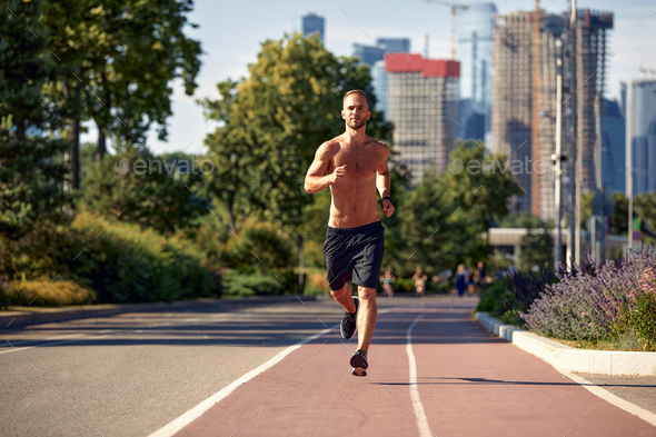 caucasian man jogging on the running track - Blonde male athlete in ...