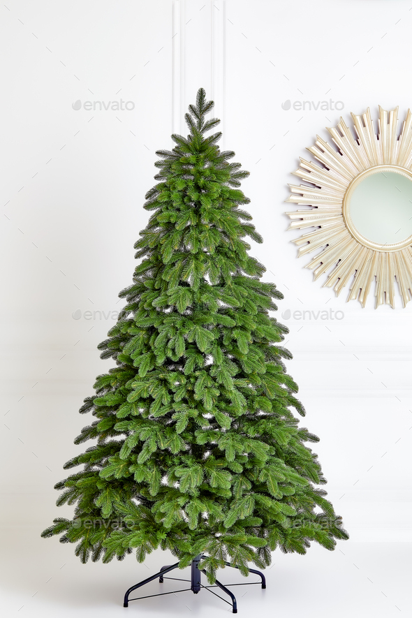 Artificial Christmas green tree without decorations on a metal stand ...