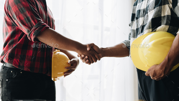 Close up handshake of two engineers. Group of industries workers meet ...