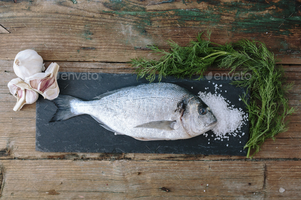 Sea Bream on a slate board with dill and salt and garlic Stock Photo by ...