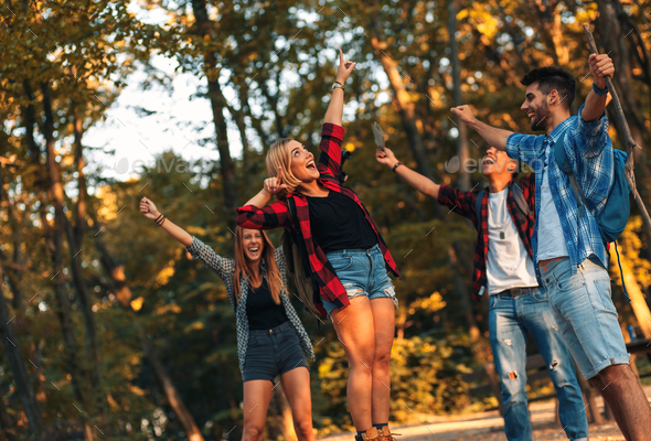 Group of four friends having fun hiking through forest together. Stock ...