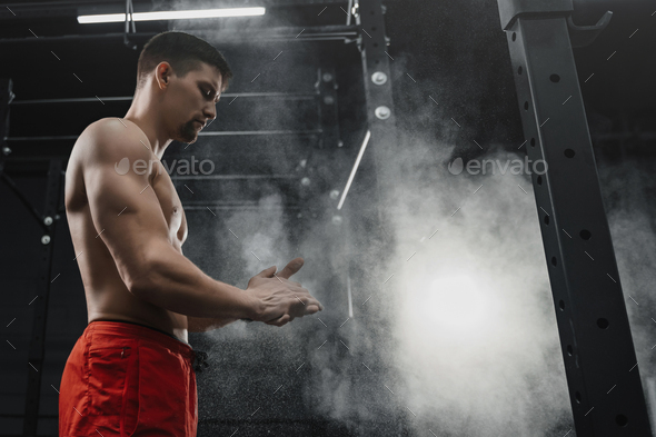 Muscular crossfit athlete clapping hands and preparing for workout at ...