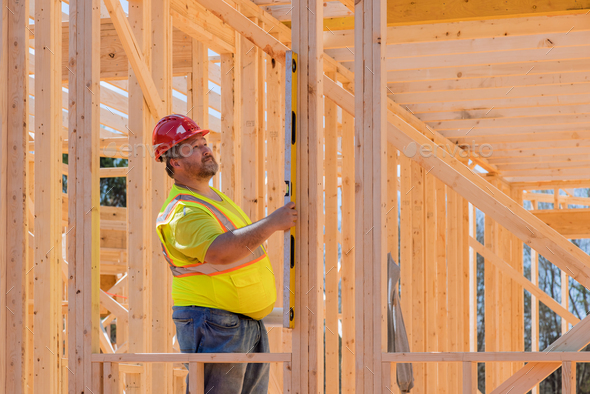 Construction engineer checks the quality of wooden frame of beams work ...