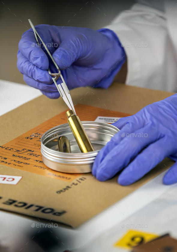 Scientific police examining a bullet cap in ballistic Laboratory ...