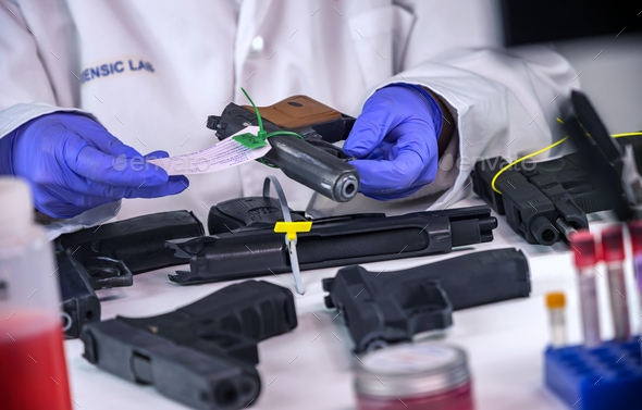 Scientific police officer examining traces of a gun in ballistic ...