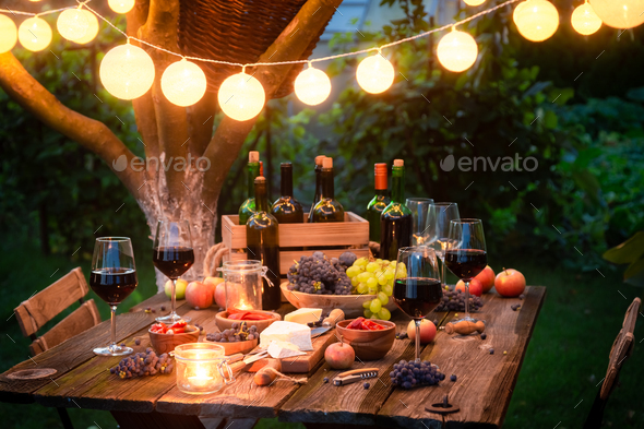 Rustic table with wine and appetizers in the summer evening Stock Photo ...