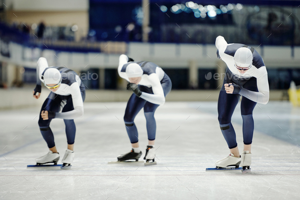 Three young male ice skaters sliding along rink on arena Stock Photo by ...