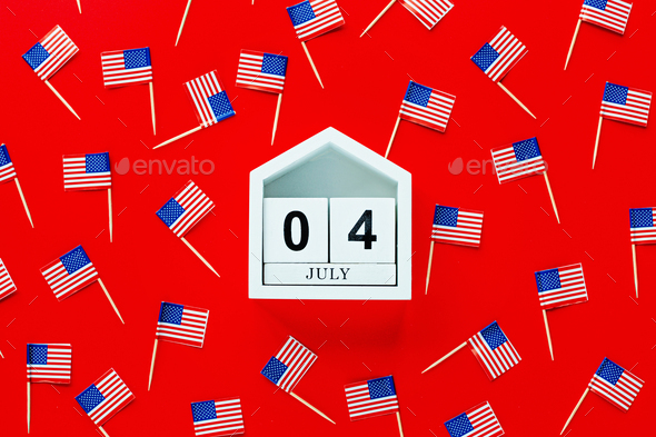 July 4th. Mockup of july 4 wooden color calendar and USA flags on red ...