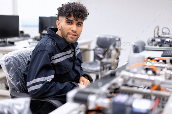 Engineer sitting in robot fabrication room quality checking electronic ...
