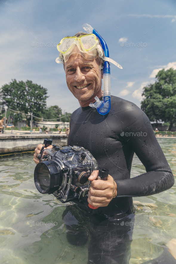 Portrait of happy man with underwater DSLR camera case in a lake Stock ...