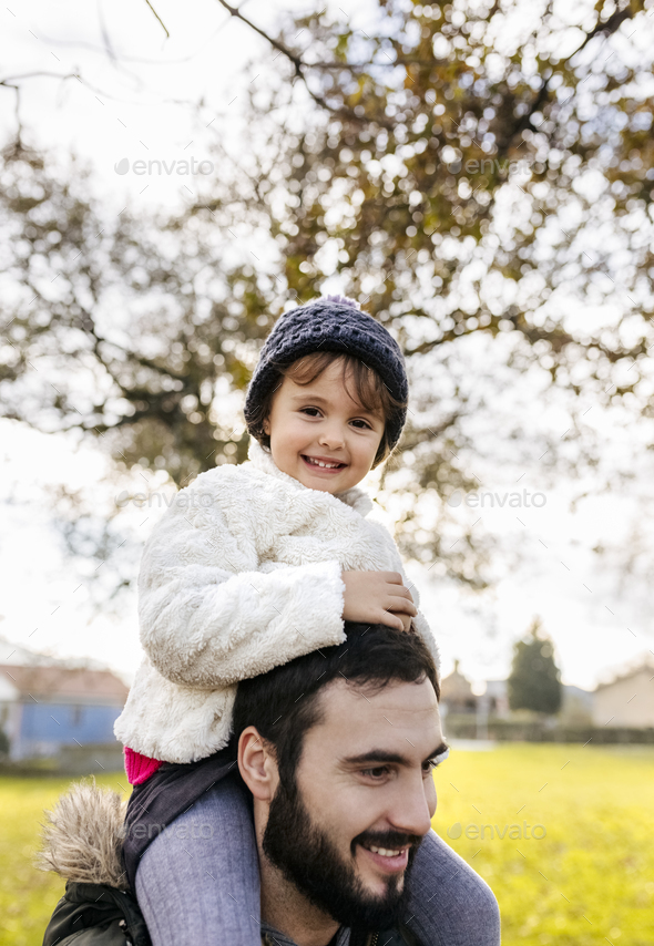 Portrait of happy little girl on shoulders of her father Stock Photo by ...