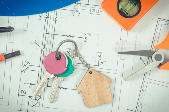 Keys with house shape and electrical construction drawings with work ...