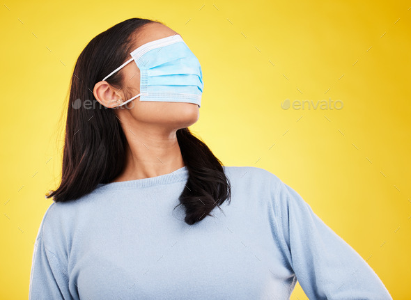 Covid, face mask and blindfold with woman in studio for medical, crazy ...