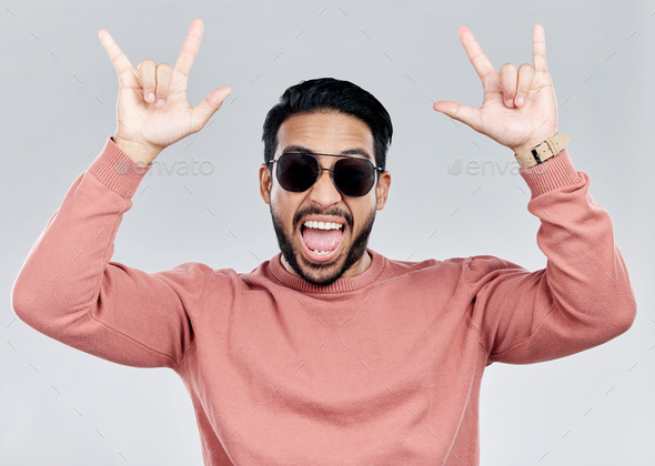 Portrait, rocker and hand gesture with a man in studio on a gray ...