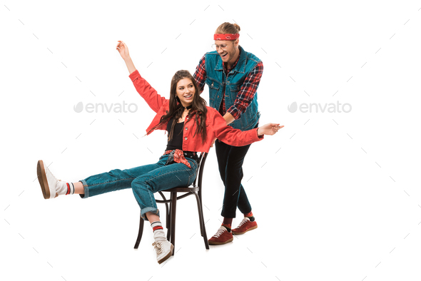 hipster girl with wide arms sitting on chair while her happy boyfriend ...