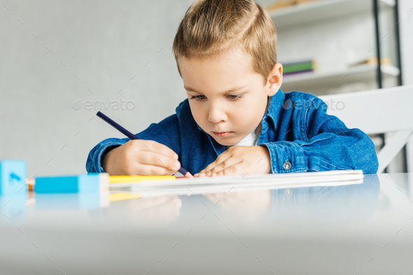 concentrated little kid drawing with color pencils at home Stock Photo ...
