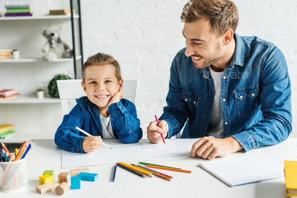 handsome young father drawing with smiling little son at home Stock ...