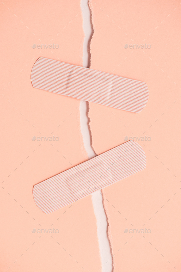 top view of adhesive bandages holding two parts of torn paper Stock ...