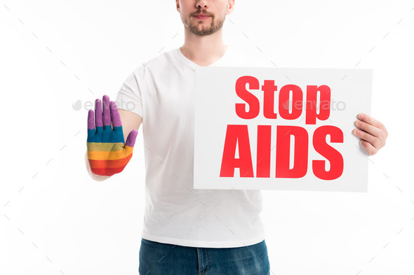 cropped image of man showing stop sign with hand painted in rainbow and ...