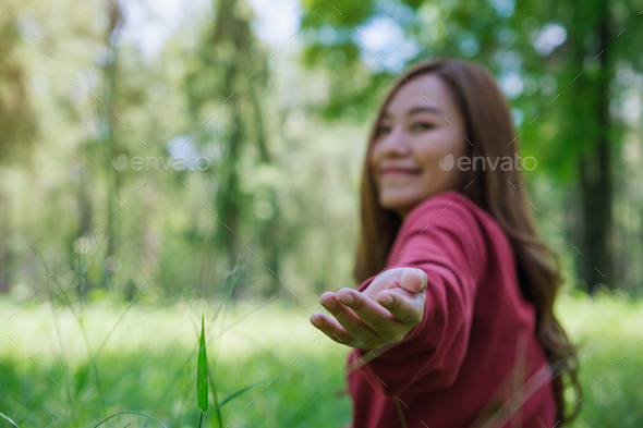 A beautiful asian woman holding hands and leads into the park for ...