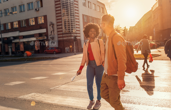 Smiling couple enjoying walking and exploring city street during the ...