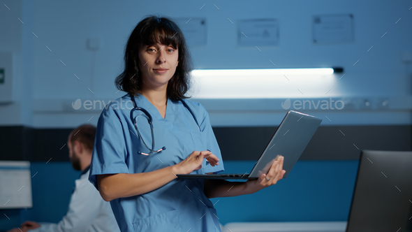 Practitioner nurse holding laptop computer analyzing patient illness ...