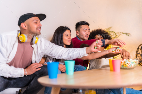 Group portrait of multiethnic friends eating popcorn and drinking soda ...