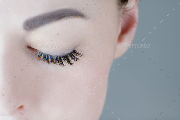 Close-up of closed eye with magnificent long eyelashes, flawless skin ...