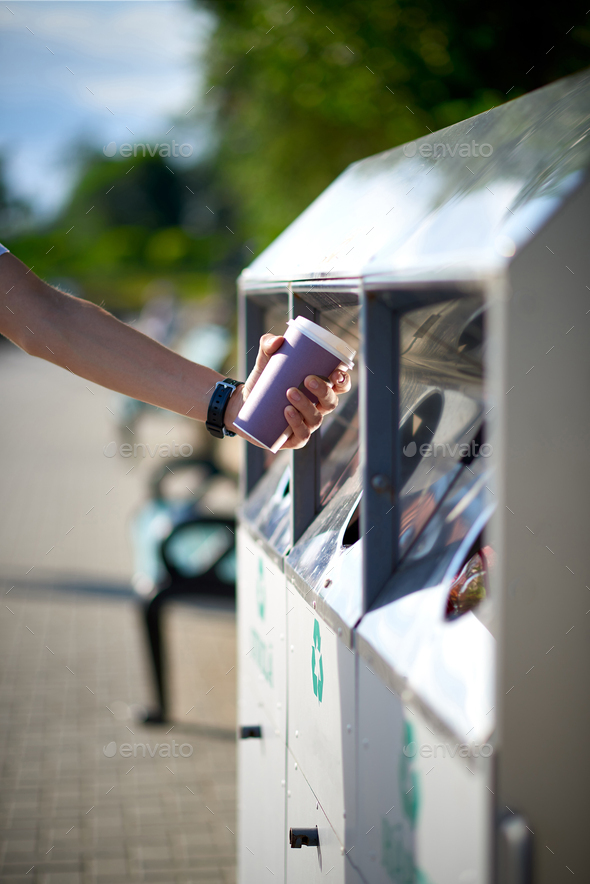 Man throwing paper coffee cup in waste sorting bin of the park Stock ...