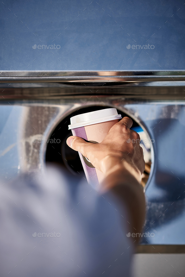 Man throwing paper coffee cup in waste sorting bin of the park Stock ...