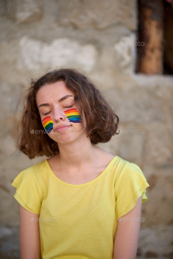 Girl feeling intimidated with pride flag on her cheeks Stock Photo by ...