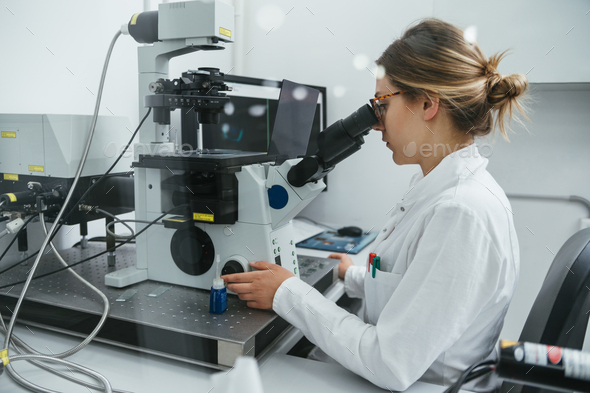 Laboratory technician using microscope in lab Stock Photo by westend61