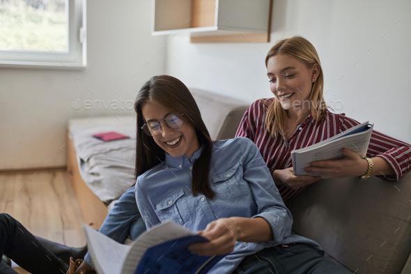 Happy students in dormitory learning together Stock Photo by westend61