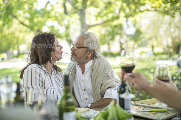 Senior couple sharing spaghetti at outdoor table Stock Photo by westend61