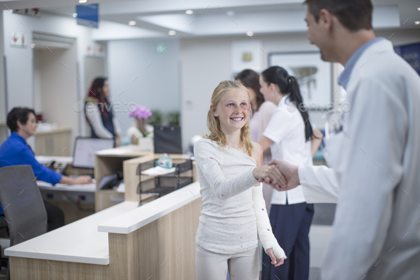 Sick girl greeting doctor at reception area in hospital Stock Photo by ...