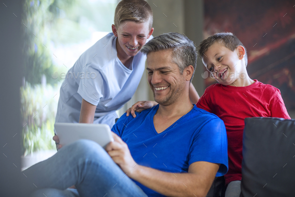 Children looking with their father on digital tablet Stock Photo by ...