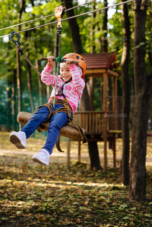 Girl climbing a rope trail in an adventure rope park. Stock Photo by ...