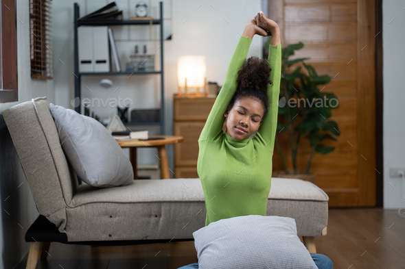 Young calm black woman relaxing in modern living room, lazy happy ...