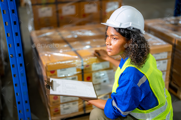 Female warehouse worker arranging of product in cardboard box in shelf ...