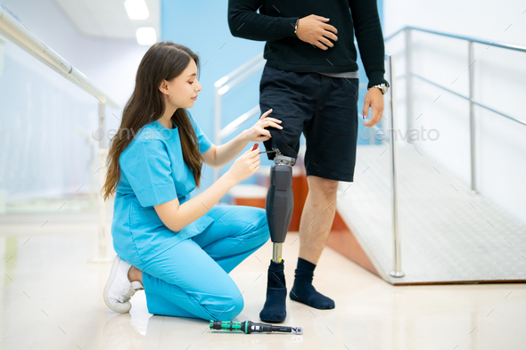Orthopedic technician adjusting mechanism on prosthetic leg for ...